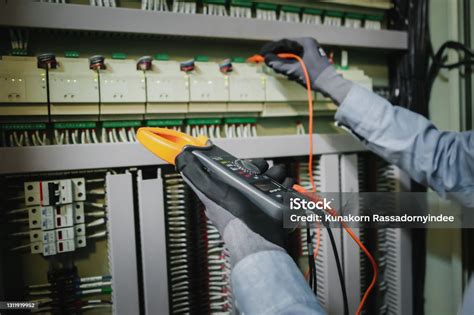 전기 엔지니어는 보호 릴레이에서 전기 설치 및 배선을 테스트하여 멀티미터로 측정합니다 개폐 장치에 대한 스톡 사진 및 기타
