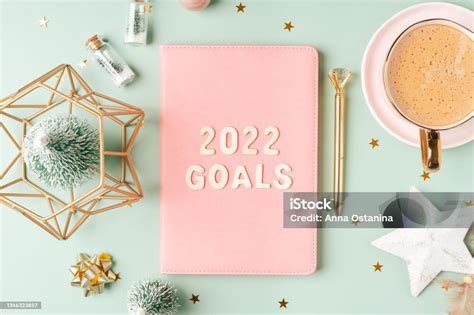 2022 골 문자 텍스트 와 상단 보기 데스크톱 크리스마스 핑크 메모장 플래너 커피 한 잔 촛불 크리스마스 장식 노트북 및 문구와 녹색 민트 테이블 배경에 플랫 누워 0명에