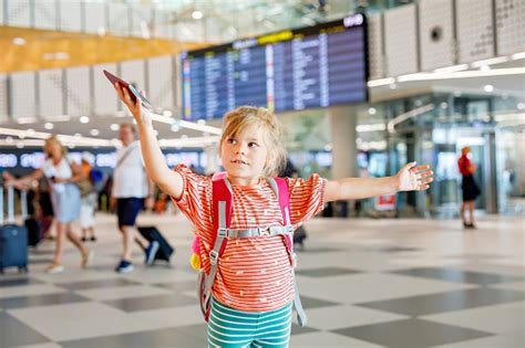 공항 터미널에 있는 어린 미취학 소녀 비행기로 휴가를 가는 행복한 아이 여권과 가방을 들고 웃는 아이 가방에 대한 스톡 사진 및