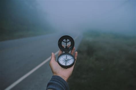 Premium Photo Cropped Hand Holding Navigational Compass Against Sky