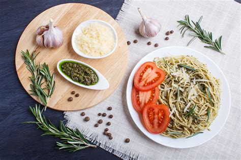 페스토 소스를 곁들인 스파게티 파스타 토마토 치즈를 검은 색 나무 배경의 린넨 식탁보에 얹어 놓습니다 상단보기 평평한 평신도 0명에 대한 스톡 사진 및 기타 이미지 Istock