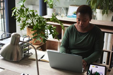 친환경 작업 공간 비즈니스 노트북에 있는 흑인 여성이 온라인 프로젝트 보고서 및 연구 작업을 하고 있습니다 창조적 인 사무실 계획 및 웹 사이트 인터넷 및 이메일을위한