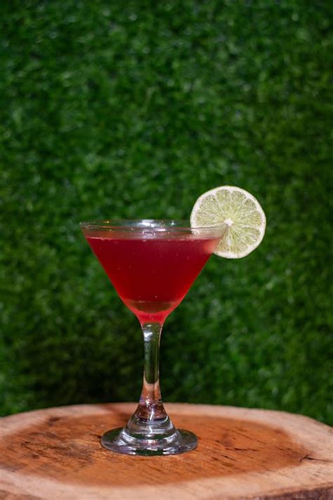 나무 위에 라임 장식이 있는 우아한 레드 칵테일 · 무료 스톡 사진