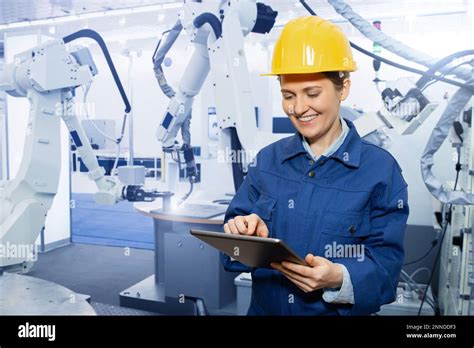 Woman Engineer Uses A Digital Tablet To Control Robots In A Smart
