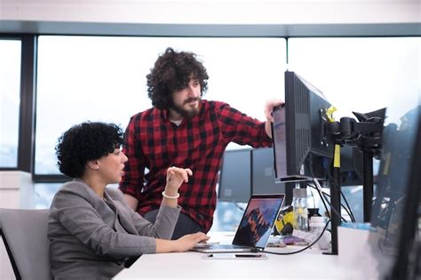 Premium Photo Young Software Developers Couple Using Laptop And Desktop Computer While Writing
