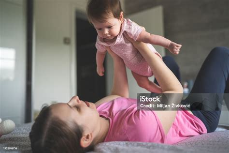 젊은 성인 백인 어머니는 그녀의 4 개월 된 아기 딸과 함께 놀고 있는 동안 집 육아와 모성 가족 및 행복 사랑 개념의 침실에 누워 2 5 개월에 대한 스톡 사진 및 기타