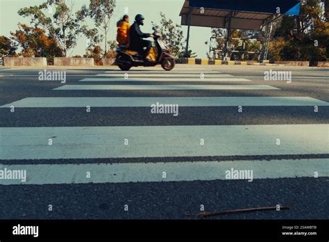 A Dynamic Image Captures A Scooter Crossing A Pedestrian Crosswalk The Blurred Motion Conveys A