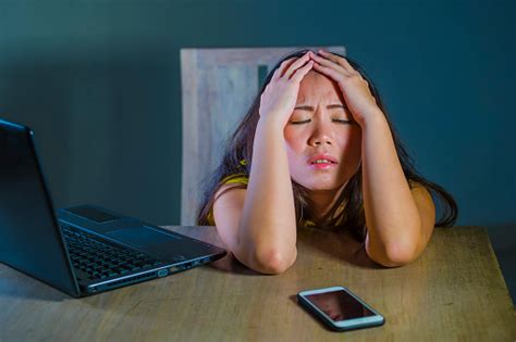 극적인 초상화 무서 워 하 고 아시아 한국 십 대 소녀 또는 젊은 노트북 컴퓨터와 휴대 전화 사이버 스토킹과 인터넷 비밀 번호 해킹으로 괴 롭 혔 던 왕 따 고통을 강조
