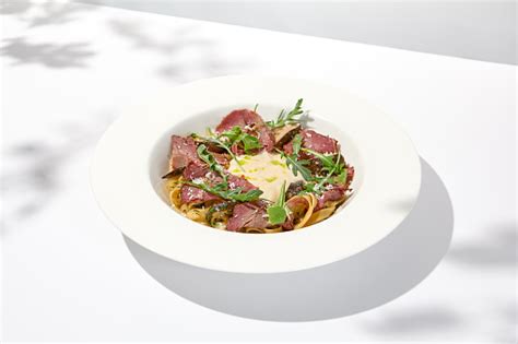 파스타 라미와 치즈와 크림 소스를 곁들인 수제 파스타 흰 테이블에 쇠고기와 소스를 곁들인 이탈리아 파파델 햇볕의 그림자가있는 여름 식사 이탈리아 음식 0명에 대한 스톡 사진