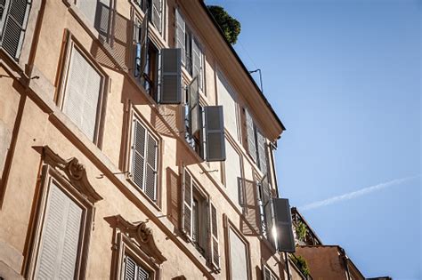 나무 셔터가 있는 오래된 로마의 주거용 건물의 전형적인 이탈리아 지중해 외관 이 건축물은 도시의 고대 지역의 역사적인 매력과 전통적인 디자인 요소를 반영합니다 0명에 대한