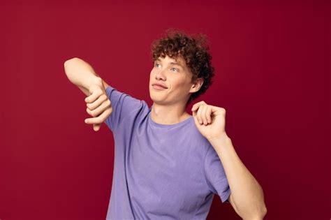 Premium Photo Curly Man In A Tshirt On A Colored Background Posing