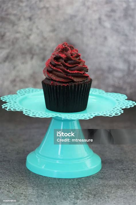 개별 수제 초콜릿 컵케이크 브라운 청록색 케이크 스탠드의 종이 케이크 케이스 탈수 된 라즈베리 먼지 회색 배경으로 코팅 된 초콜릿 버터 착빙 파이프 소용돌이의 이미지 전경에
