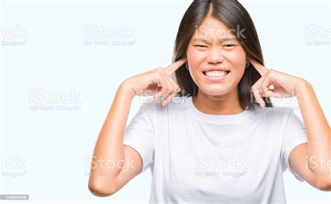 시끄러운 음악의 소음에 대 한 짜증이 식이 손가락으로 귀를 덮고 격리 된 배경 위에 젊은 아시아 여자 청각 장애인 개념입니다 가리기에 대한 스톡 사진 및 기타 이미지