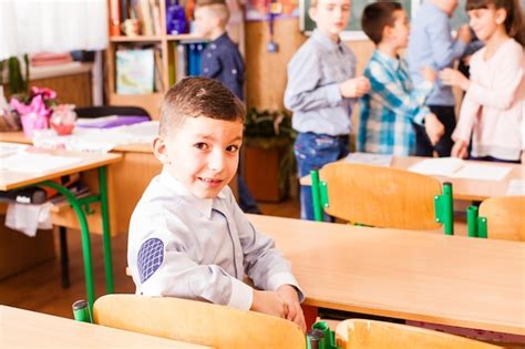 Menino Sentado Na Cadeira Na Sala De Aula Durante O Intervalo Foto