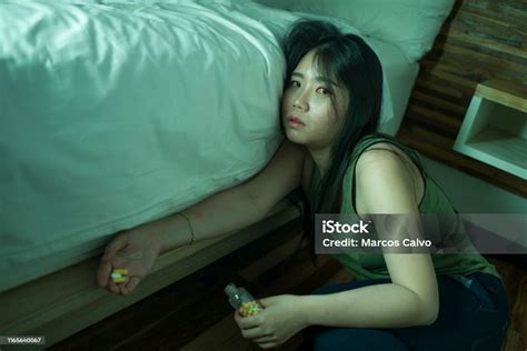 젊은 아름다운 절망과 낭비 중독자 아시아 일본 여자는 아픈 느낌과 우울한 고통 우울증 고장 에 가정 침실 바닥에서 약물 과다 복용 건강관리와 의술에 대한 스톡 사진 및 기타