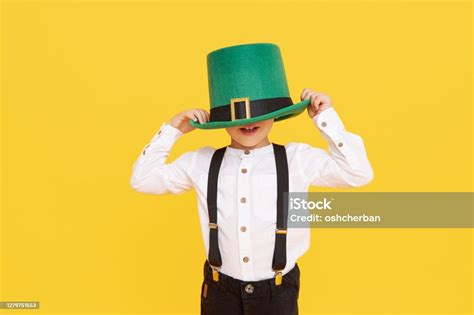 노란 배경에 녹색 레프레툰 모자를 쓰고 어린 아이를 미소 짓는다 성 패트릭 데이 축하 재미있는 얼굴 3월에 대한 스톡 사진 및 기타 이미지 Istock