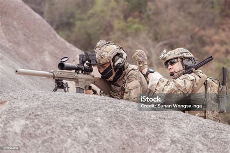 Soldiers In Camouflage Military Uniforms Carrying Weapons