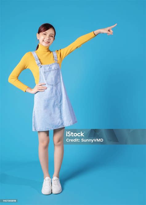 파란색 배경에 서 있는 어린 아시아 소녀의 전체 길이 사진 가리키기에 대한 스톡 사진 및 기타 이미지 가리키기 전신 20 24세 Istock