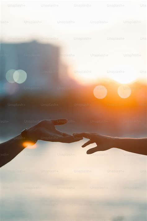 두 손이 물 위로 서로를 향해 뻗어 있습니다 사진 Unsplash의 기쁨 이미지