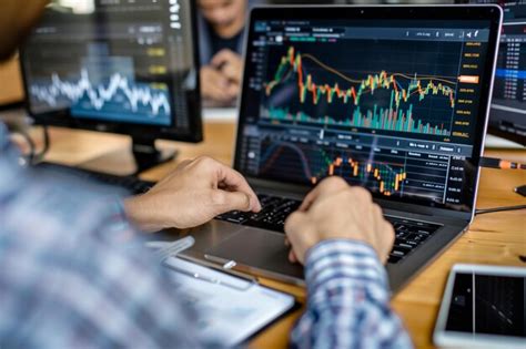 A Man Is Working On A Laptop With A Graph Showing The Graph Of Graph