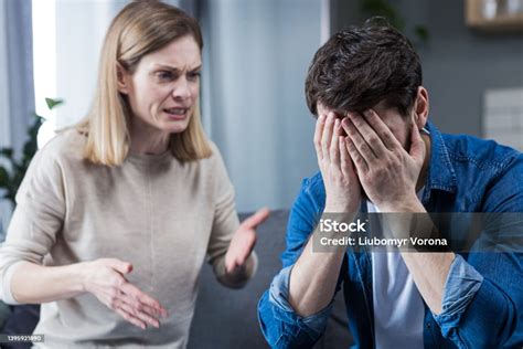 가족 갈등 다툼 오해 그 여인은 절망에 빠진 남편에게 울면서 소리친다 설명이 필요합니다 남자는 손으로 얼굴을 가리며 귀를 기울인다 집에서 소파에 앉아 40 44세에 대한