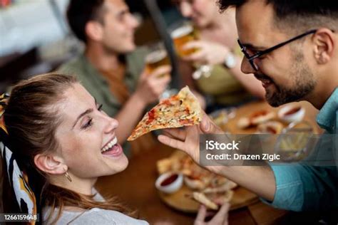술집에서 친구들과 식사를하면서 피자 조각을 공유하는 행복한 커플 커플에 대한 스톡 사진 및 기타 이미지 커플 피자 피자집