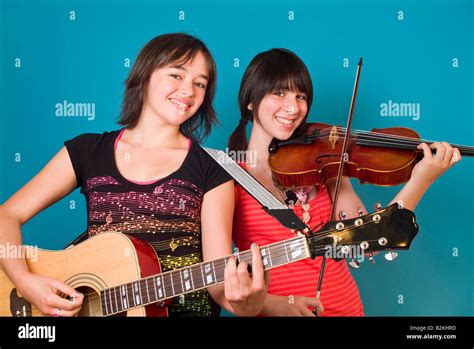 Two Smiling Girls Holding String Instruments As If Ready To Entertain You Stock Photo Alamy