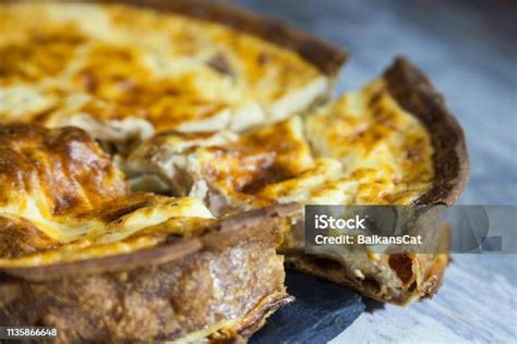 소박한 나무 테이블에 표시에 전통적인 프랑스 키 쉬 로렌 파이의 슬라이스를 닫습니다 그것은 프랑스 동부 Flan 치즈 우유 크림 및 햄으로 만든 패스트리의 상징적 인