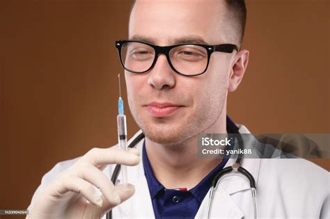 의사 유니폼을 입은 잘 생긴 남자가 주사기를 들고 행복하게 웃고 초상화 스튜디오 촬영 주사기에 대한 스톡 사진 및 기타 이미지 주사기 가리키기 의사 Istock