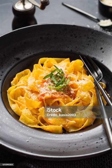 전통적인 이탈리아 파사트 소스를 곁들인 페투치네 파스타와 어두운 배경의 블랙 플레이트에 파마산 치즈를 얹어 먹습니다 맨 위 보기 건강한 식생활에 대한 스톡 사진 및 기타