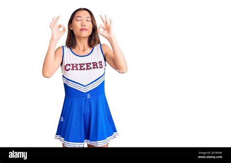 Young Beautiful Chinese Girl Wearing Cheerleader Uniform Relaxed And