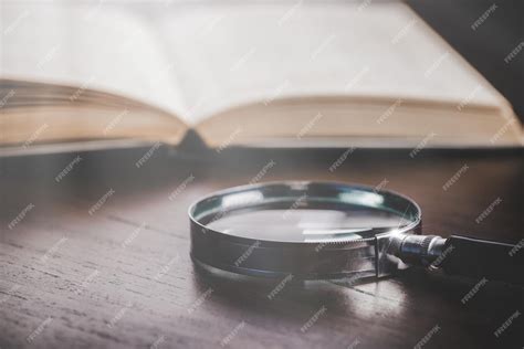 Premium Photo Open Book With Magnifying Glass On Wooden Desk In Information Library Of School