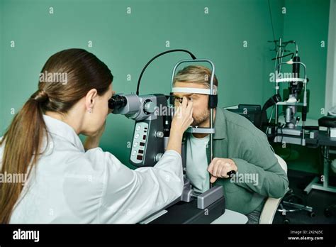 Woman Examines Mans Eyes Through A Microscope In A Doctors Office For Laser Vision Correction