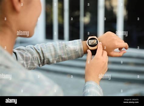 Woman Checking Home Security System Via Smartwatch App Outdoors Closeup Image Of Room Through Woman Checking Home Security System Via Smartwatch App Outdoors Closeup Image Of Room Through
