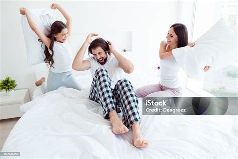 좋은 사랑 스러운 매력적인 명랑 한 명랑 한 미친 건강 한 사람에 게 기쁜 침대 즐기는 자유 시간 싸움 전투 백 일 몽 아빠 아빠 엄마 방에 흰 빛 인테리어 실내에 앉아의