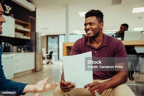 새로운 사업과의 인터뷰를 준비하는 종이 작업을 들고 매니저와 작업을 논의하는 혼합 인종 남성 사업가 2명에 대한 스톡 사진 및 기타 이미지 Istock