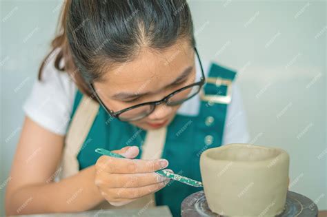 도자기 워크샵에서 점토로 세라믹 냄비를 만드는 포터 휠에서 일하는 아름다운 여성 도공 미래 세라믹 제품에 점토 제품 부품을
