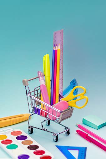 파란색 배경에 문구류와 학용품이 있는 쇼핑 트롤리 학교와 교육 배경 개념으로 돌아 가기 쇼핑 카트 학용품이 있는 슈퍼마켓 트롤리