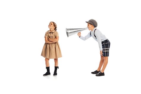 빈티지 옷을 입은 두 아이의 초상화 하얀 스튜디오 배경에 고립 된 소녀에게 메가폰으로 비명을 지르는 소년 영업 10 11세에