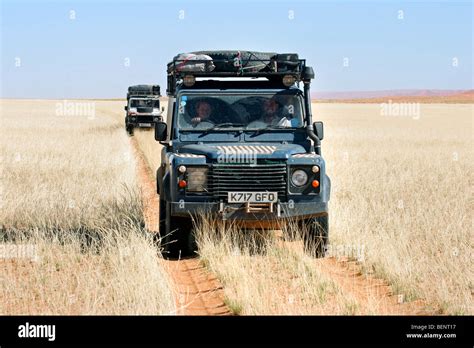 Off Road Four Wheel Drive Vehicles Driving On Savanna Track In Namibia