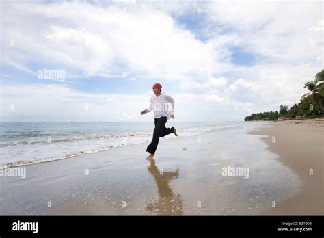 A Man Running Along The Beach Stock Photo Alamy