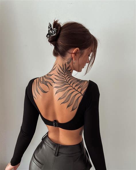 The Back Of A Womans Body With Tattoos On Her Upper And Lower Half