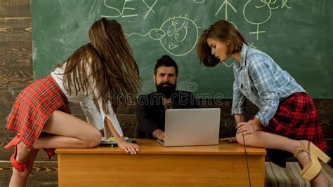 Education Let S Talk Sex Bearded Sexology Teacher Looks At Two Female Babes Stock Image