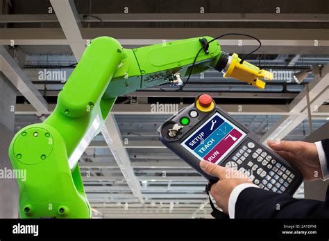 Engineer With Teach Pendant Device Programming Robot With Robotic Arm