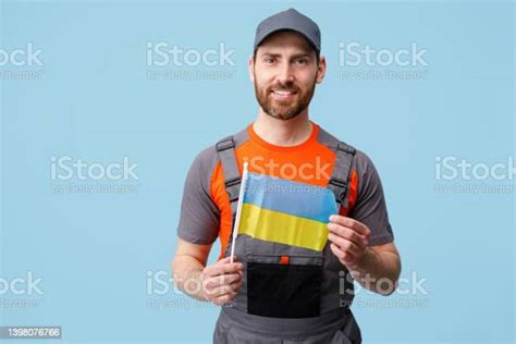 손에 우크라이나 국기를 들고 유니폼을 입은 미소 짓는 배달 남자 35 39세에 대한 스톡 사진 및 기타 이미지 35 39세 가리키기 건설 산업 Istock