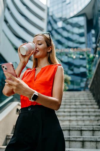 젊은 사업가의 초상화는 스마트폰을 사용하고 테이크아웃 커피를 손에 들고 현대 사무실 건물 앞에 서 있다 사람들에 대한 스톡 사진 및 기타 이미지 Istock