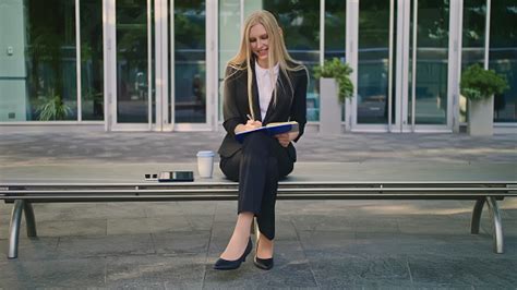 야외에서 전화로 말하는 메모장을 가진 소녀 손에 메모장을 들고 벤치에 앉아 전화 통화를 하는 현대 비즈니스 여성 거리에 대한 스톡 사진 및 기타 이미지 Istock