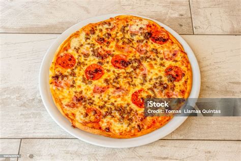둥근 백자 접시에 베이컨 갈은 쇠고기 페퍼로니 조각 모짜렐라 치즈를 듬뿍 곁들인 식인종 피자 고추류에 대한 스톡 사진 및 기타 이미지 Istock