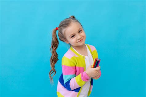 줄무늬 재킷에 색깔의 연필을 가진 귀여운 어린 소녀의 초상화 교육과 드로잉의 개념 사진 스튜디오 파란색 배경 텍스트 장소 6 7 살에 대한 스톡 사진 및 기타 이미지