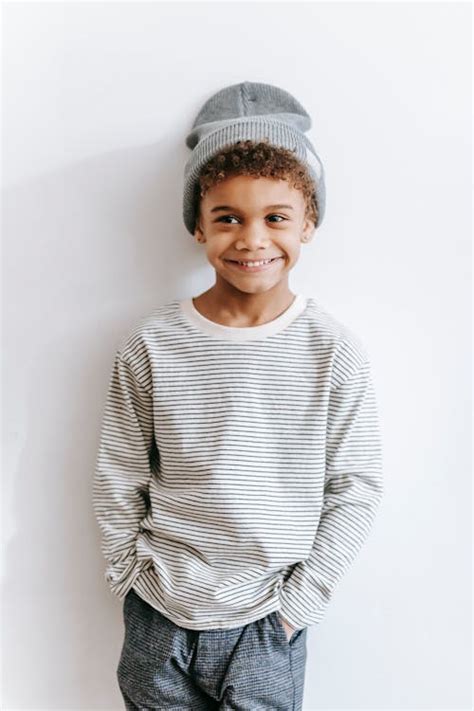 улыбающийся мальчик в бело черной полосатой рубашке с круглым вырезом и длинным рукавом